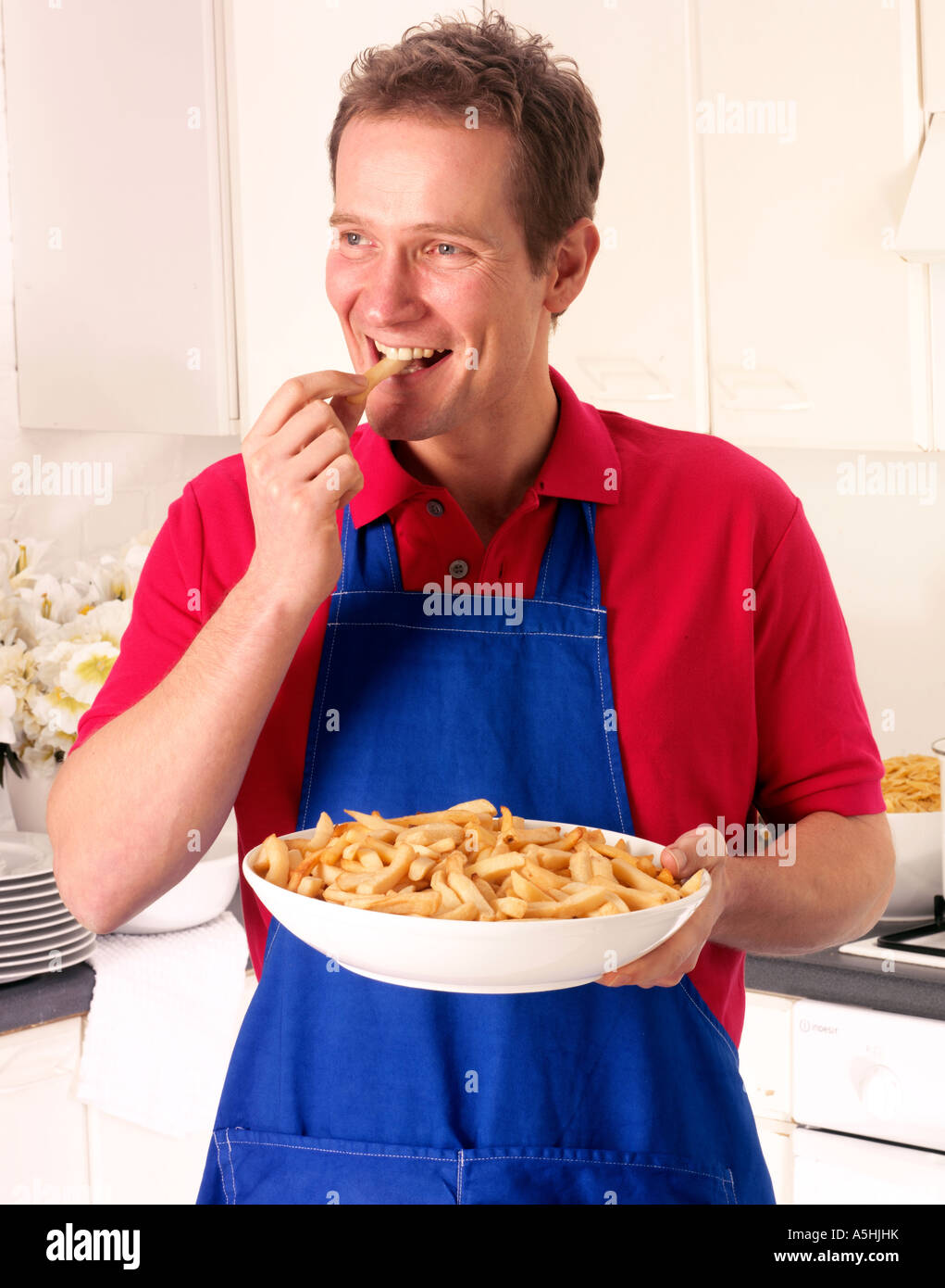 MAN IN KITCHEN EATING CHIPS Stock Photo - Alamy