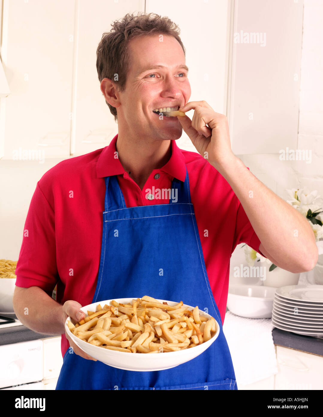 MAN IN KITCHEN EATING CHIPS Stock Photo - Alamy