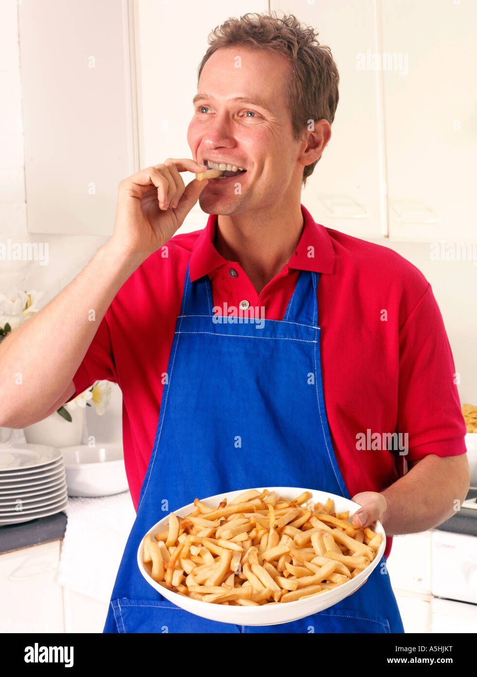 MAN IN KITCHEN EATING CHIPS Stock Photo - Alamy