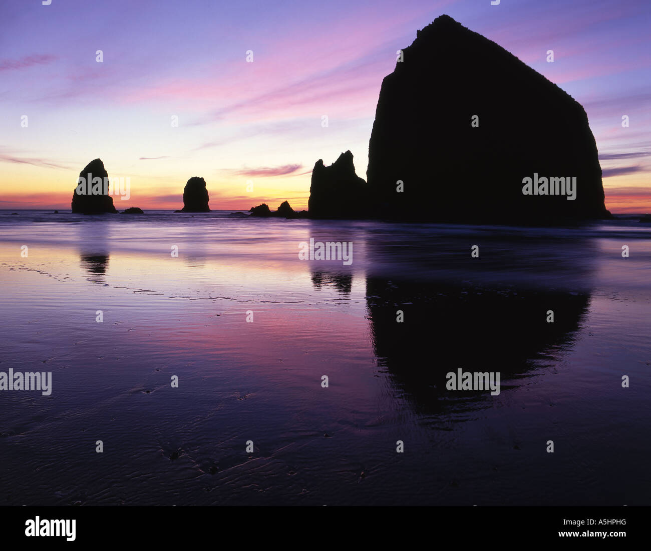 Sunset silhouettes Oregon's Haystack Rock at Cannon Beach Stock Photo ...