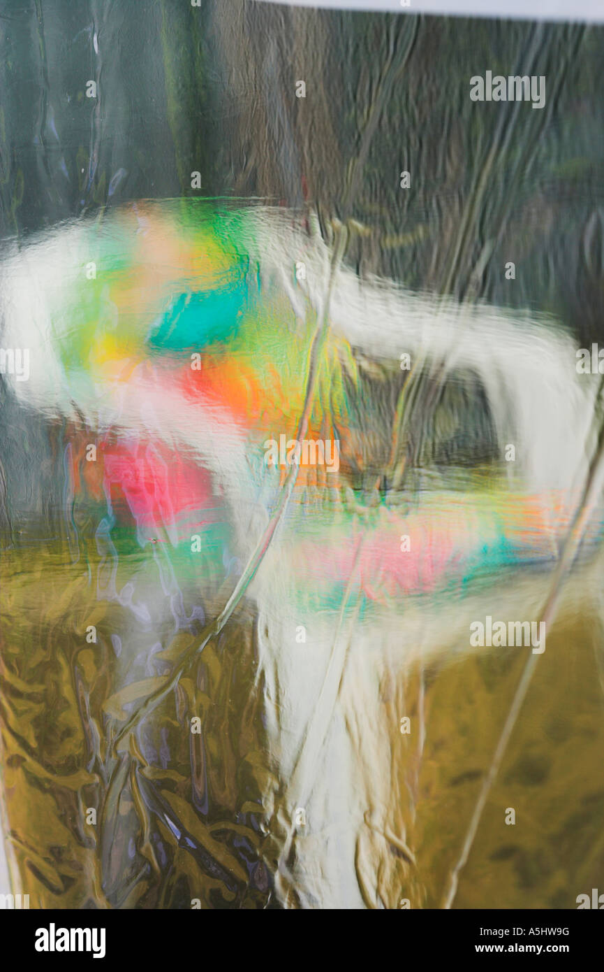white plastic garden chair on a patio distorted through a plastic ...