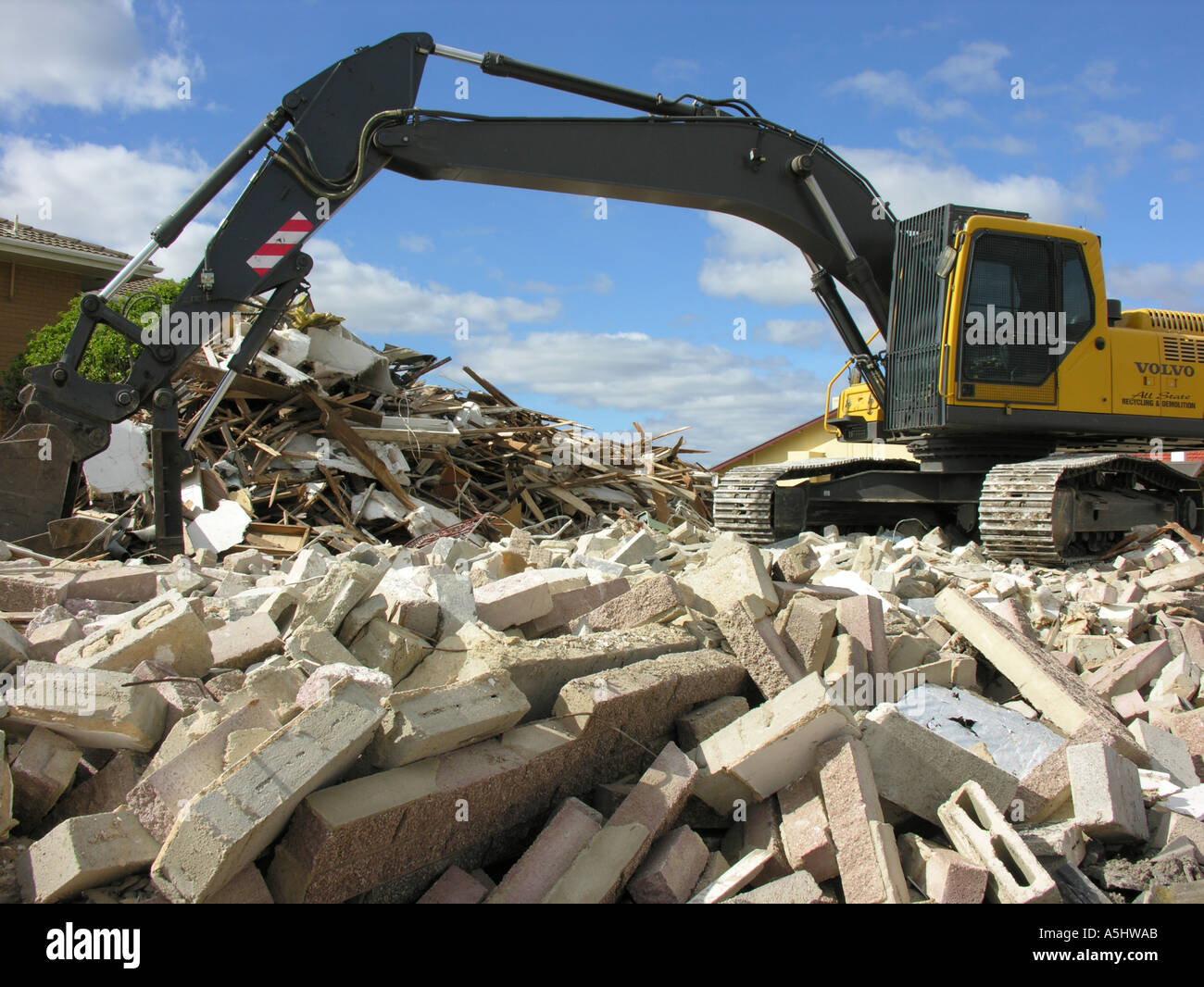 Excavator with rubble of demolished building Stock Photo - Alamy
