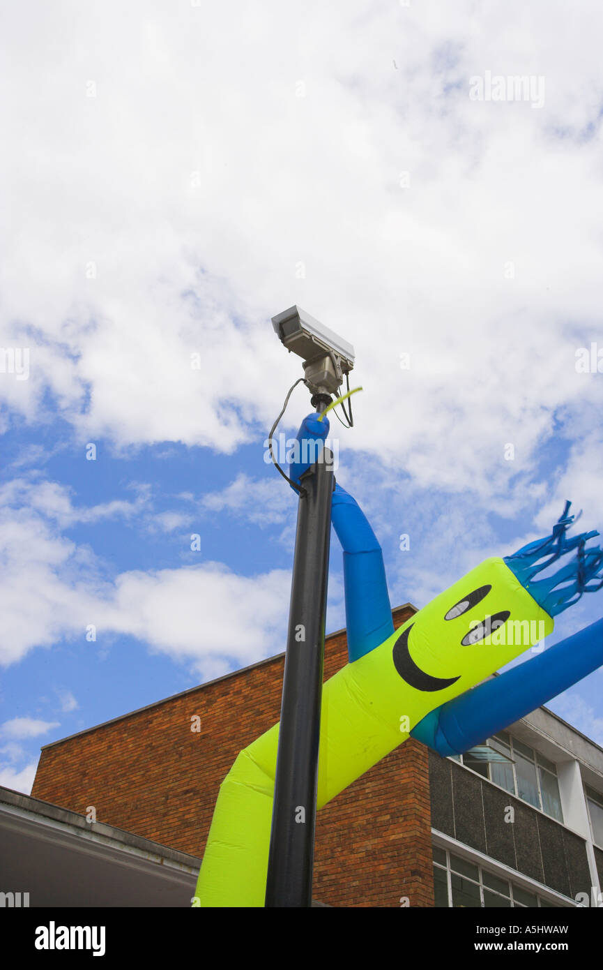 inflatable incandescent cartoon character with right arm around a CCTV ...