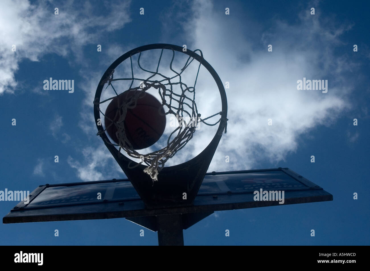 Basketball going through hoop Stock Photo - Alamy