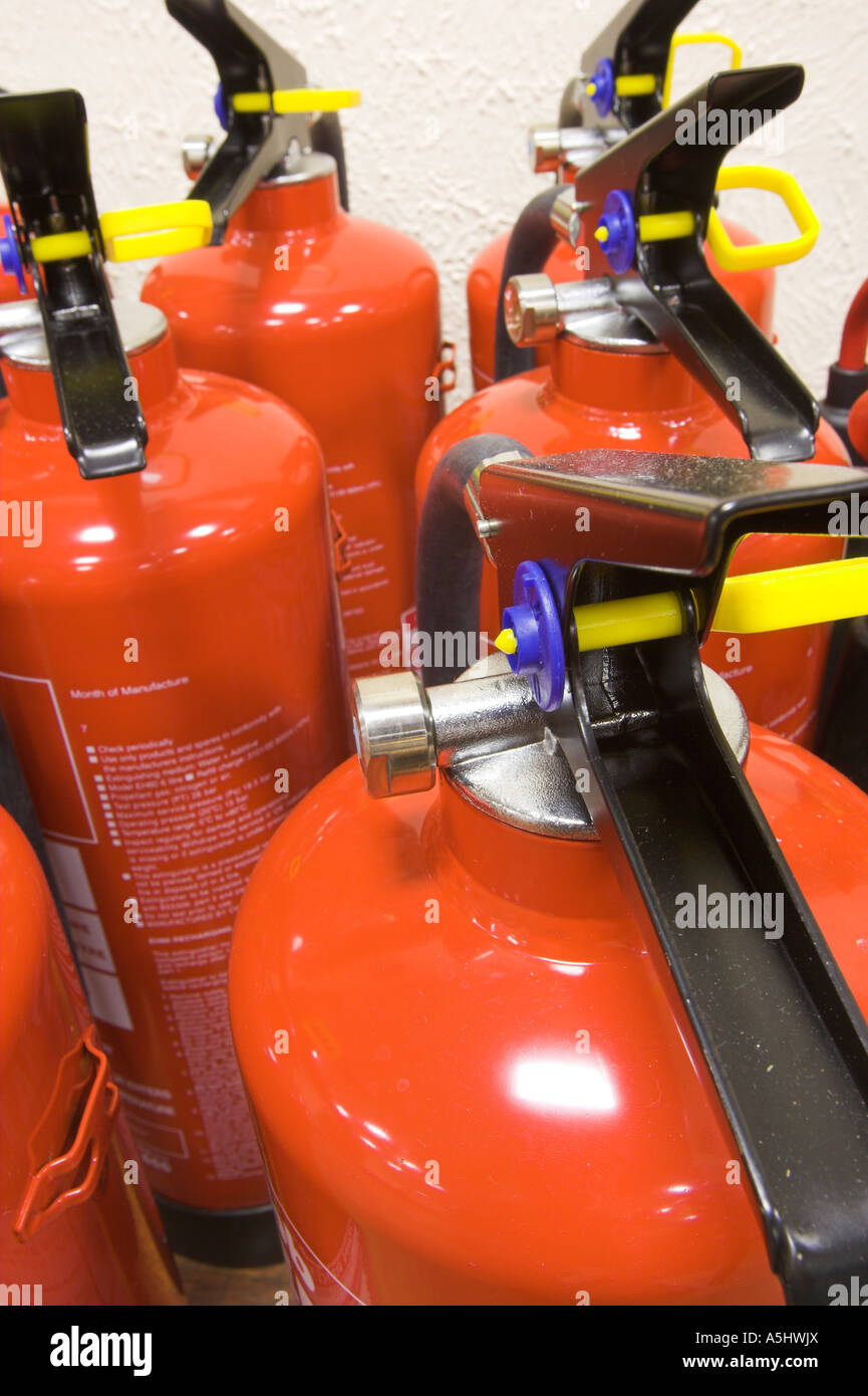 Group of new red fire extinguishers with yellow locking pins awaiting ...