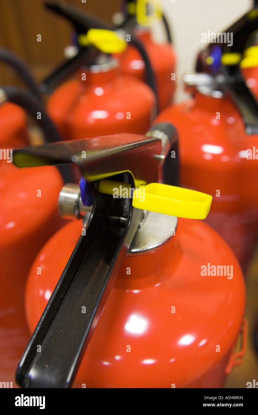 Red fire extinguishers with yellow locking pins awaiting installation ...