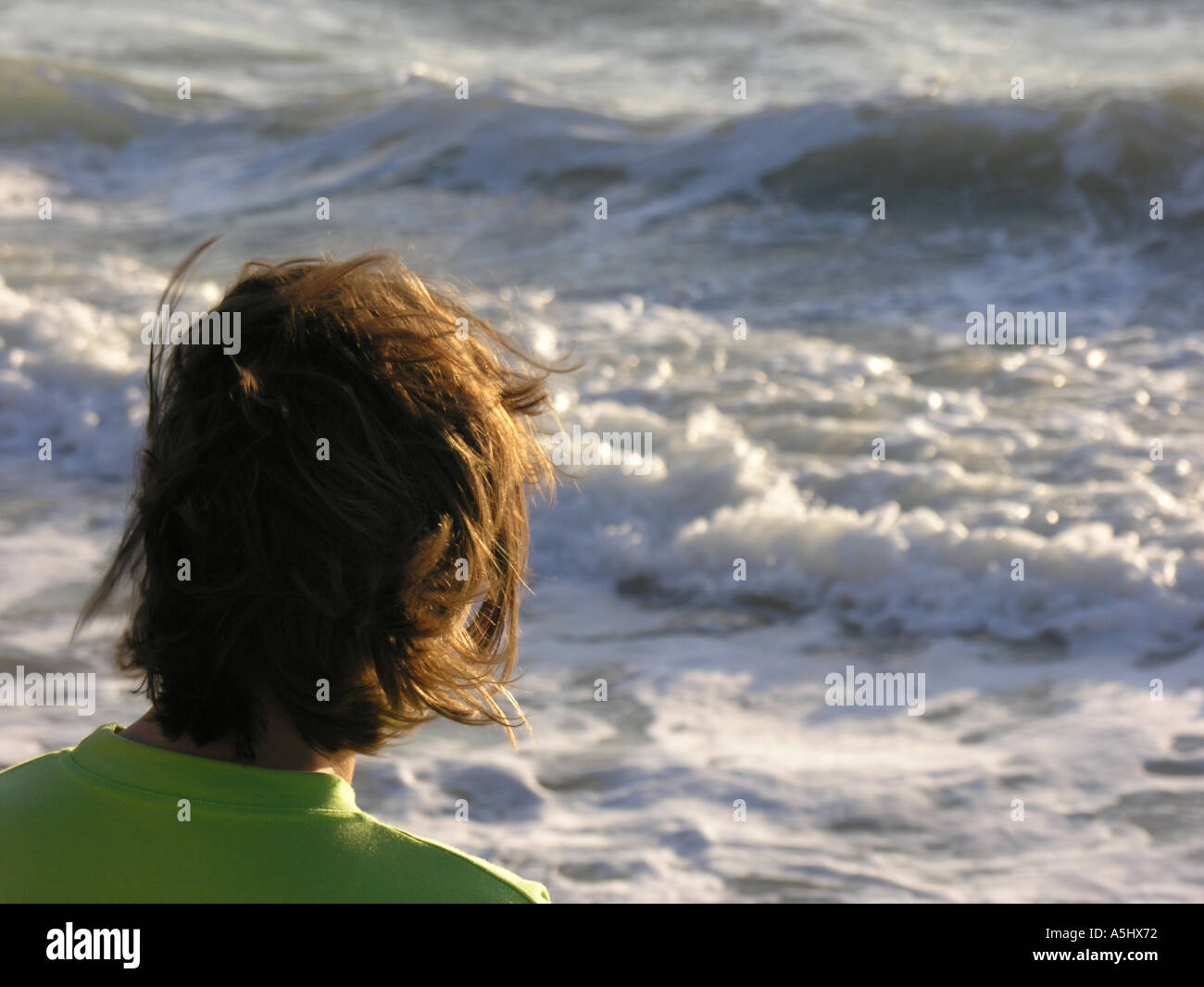 Young woman looking into troubled water Stock Photo - Alamy