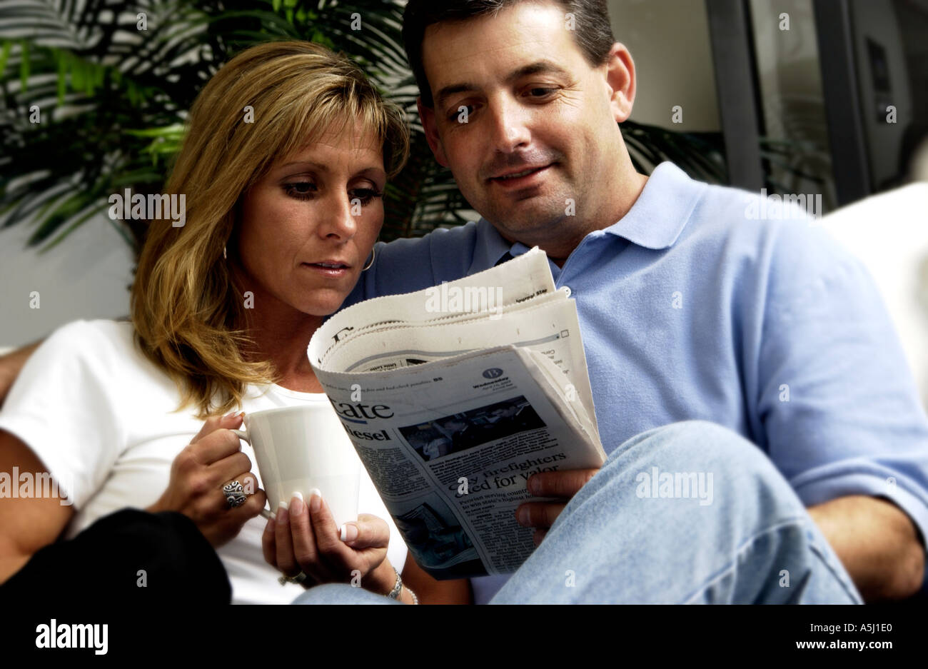 Couple reading the newspaper Stock Photo - Alamy