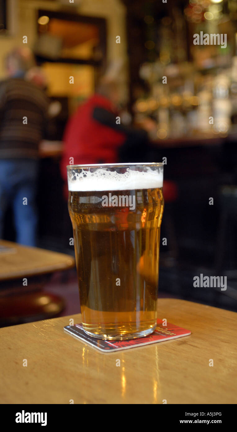 A pint of lager on a beer mat on a table in a public house Stock Photo ...