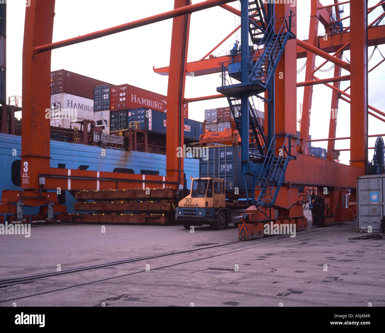 Cargo ship loading and unloading containers at freight terminal ...