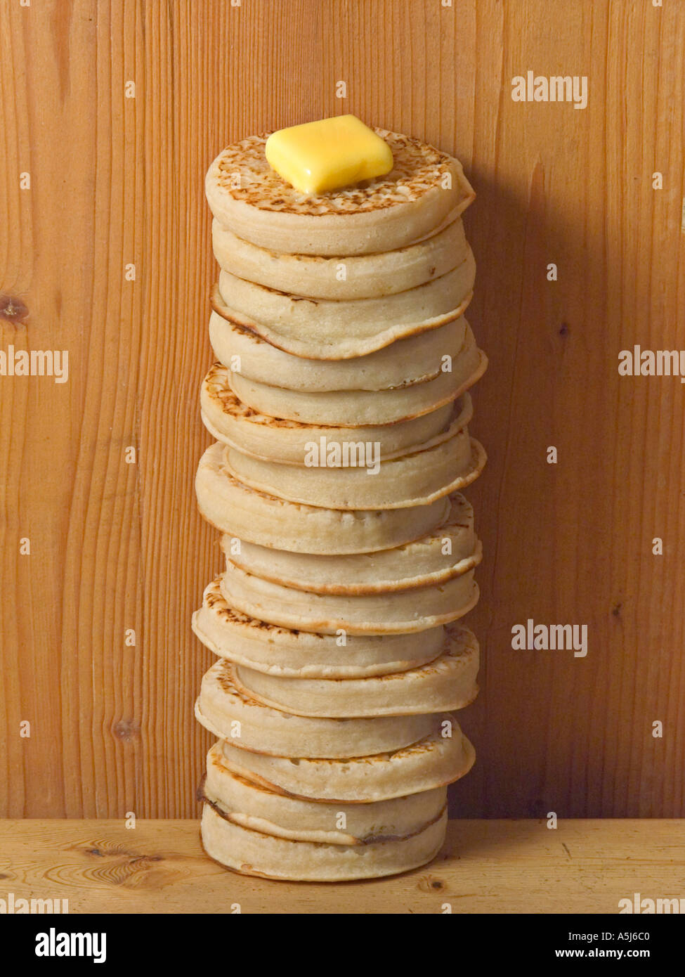 A tall stack of crumpets with melting butter on top Stock Photo - Alamy