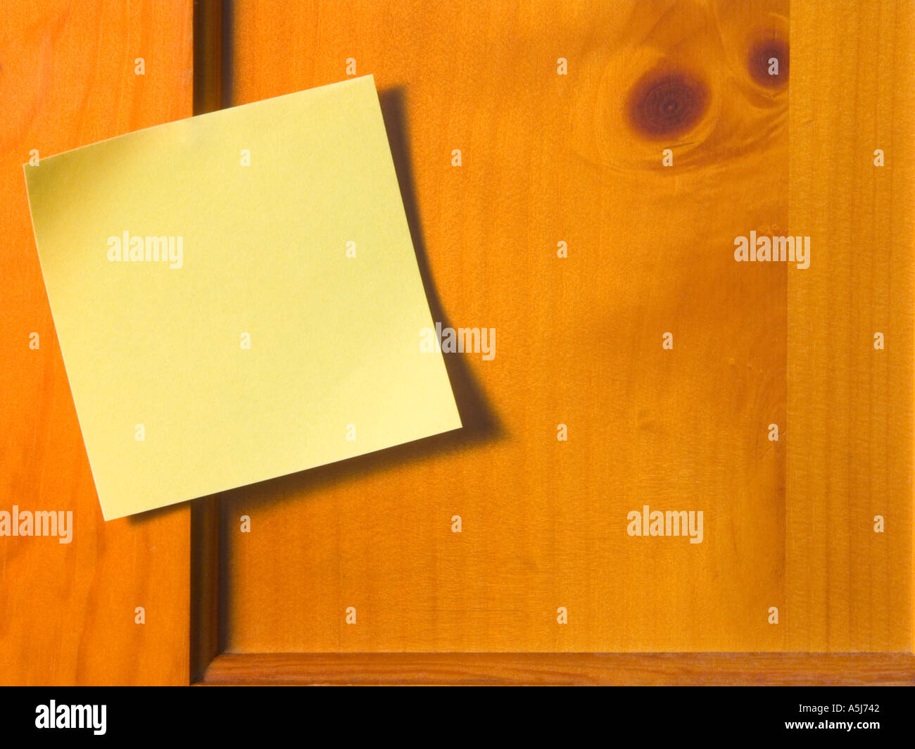 A yellow Postit note on a wooden kitchen door Stock Photo - Alamy