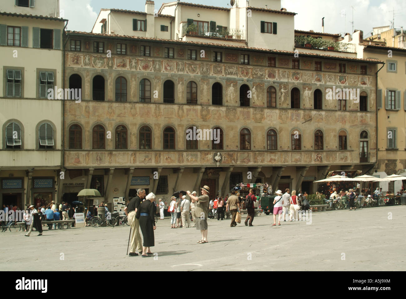 Florence locals and tourists mingle around shops and pavement bars ...