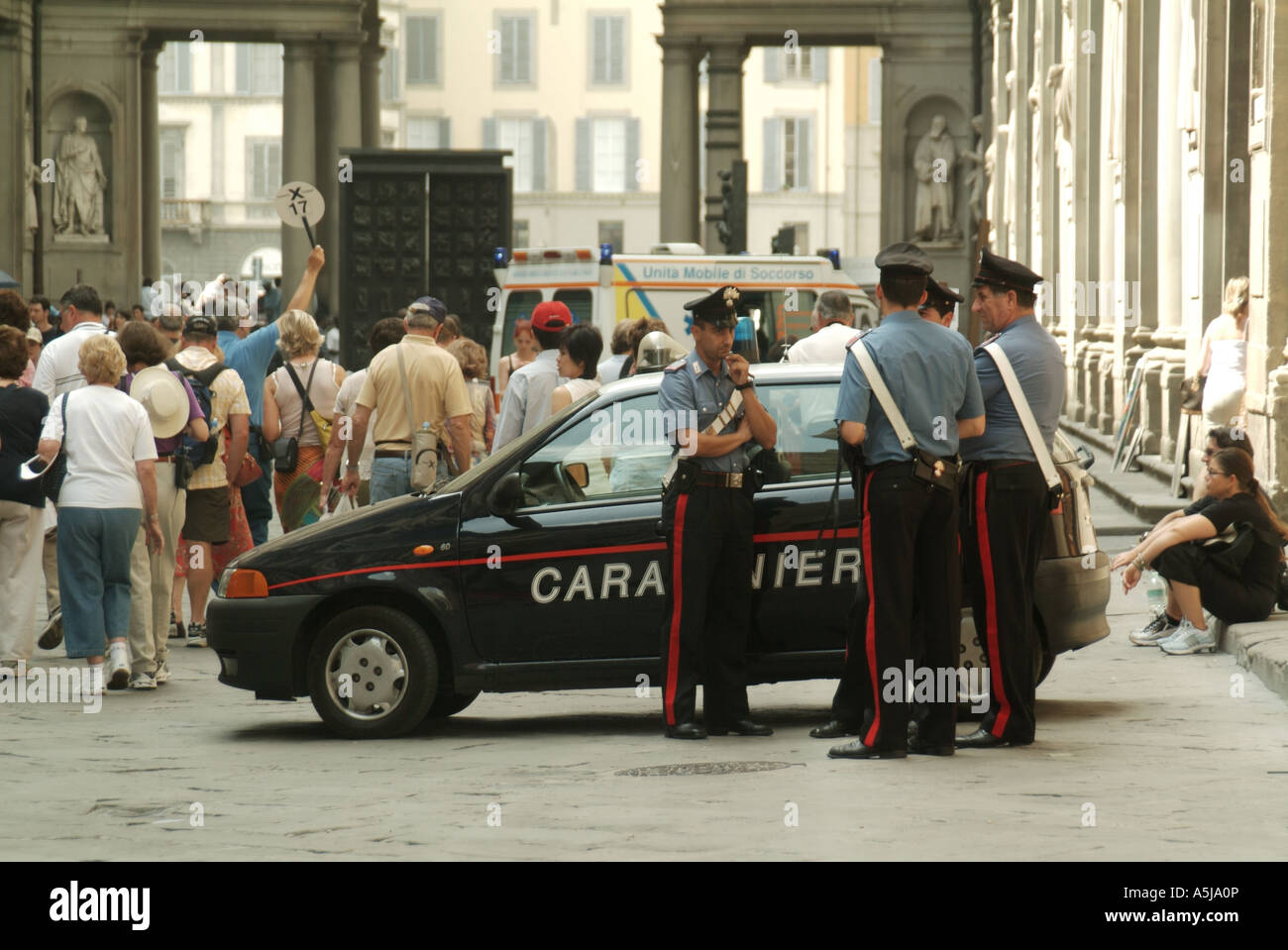 Busy street scene group of Italiian police officers standing beside ...