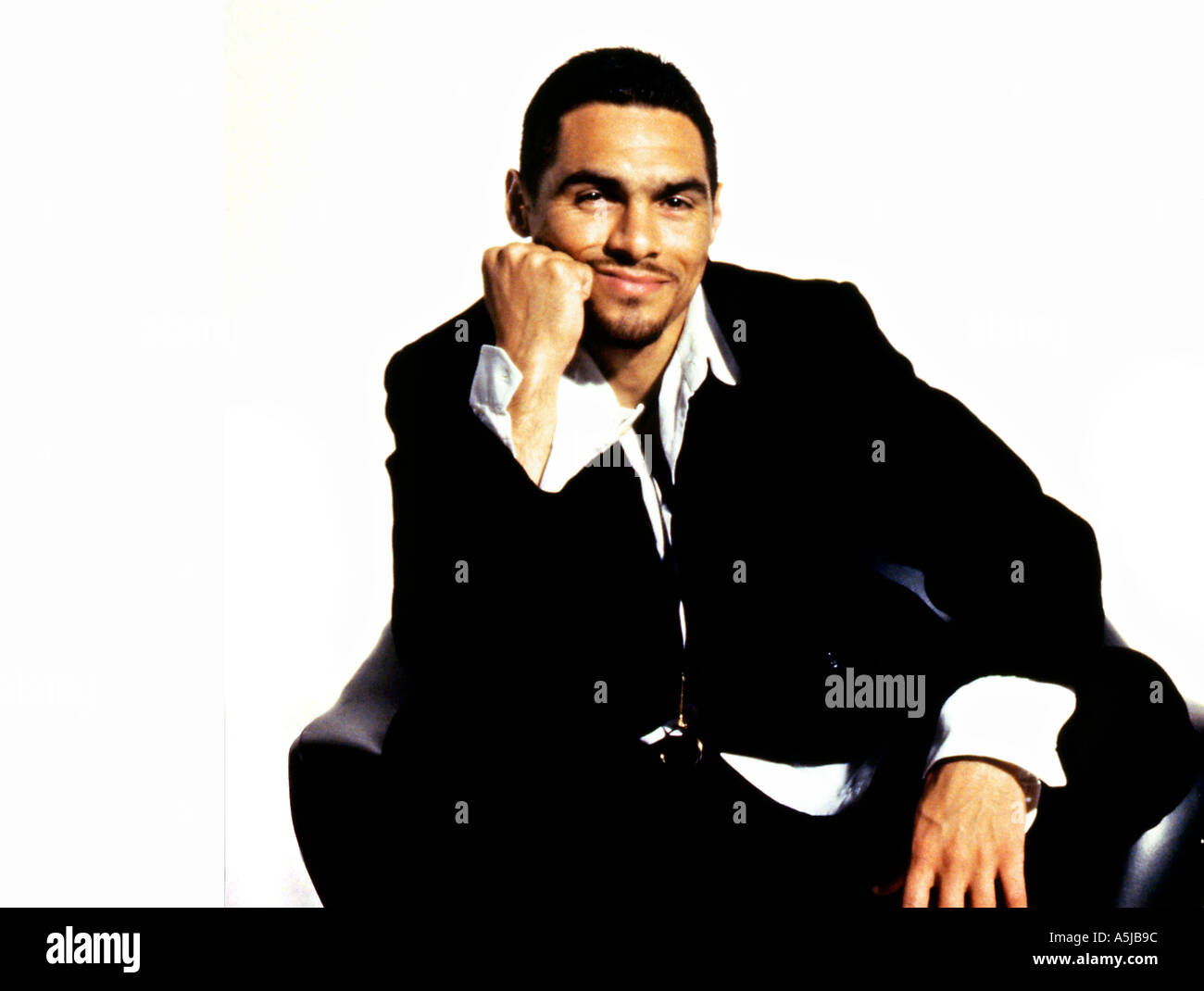 black man sitting in chair white background Stock Photo - Alamy