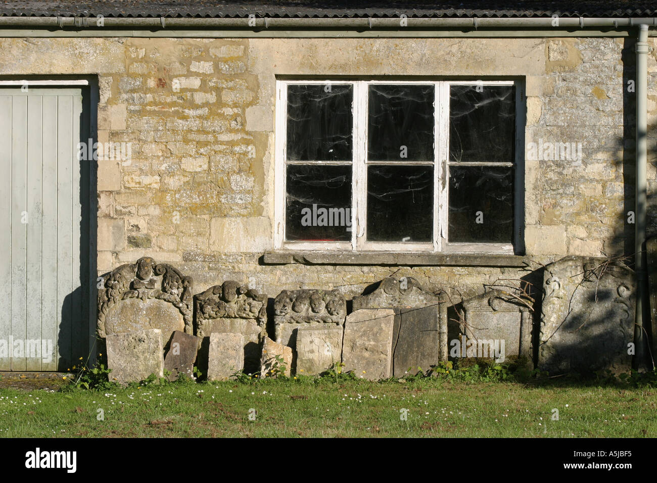 Gravestones stacked against a stone outbuilding Stock Photo - Alamy