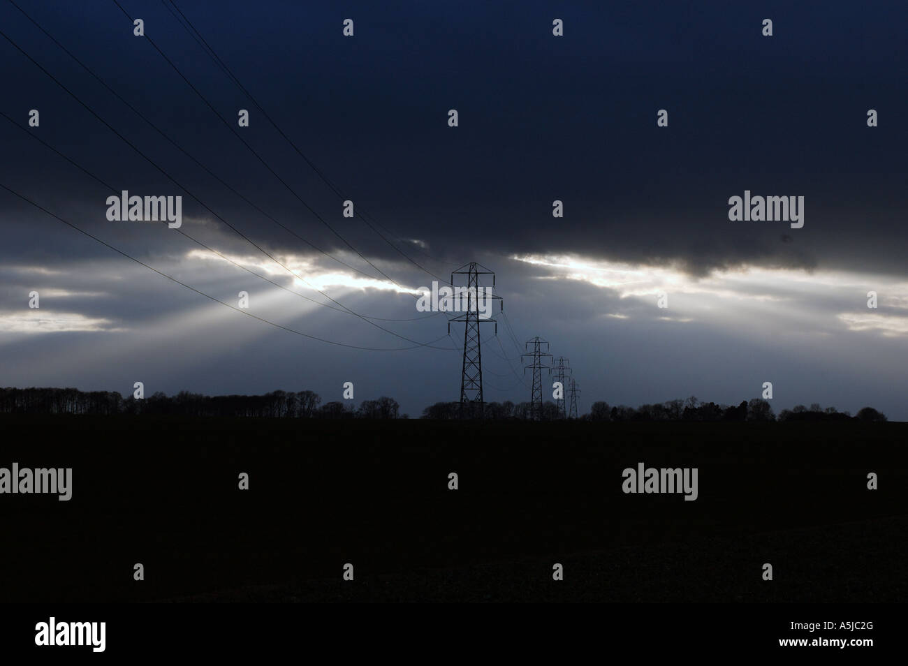Power lines silhouetted against a dramatic stormy sky Stock Photo - Alamy