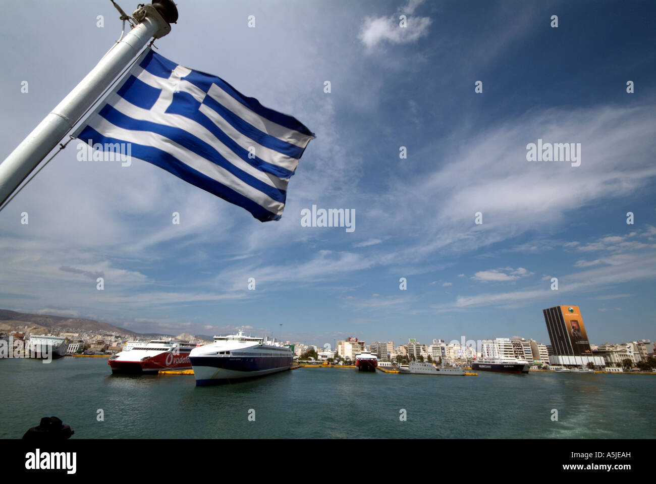 The Greek flag flying from the ferry as it departs from Piraeus Harbour ...
