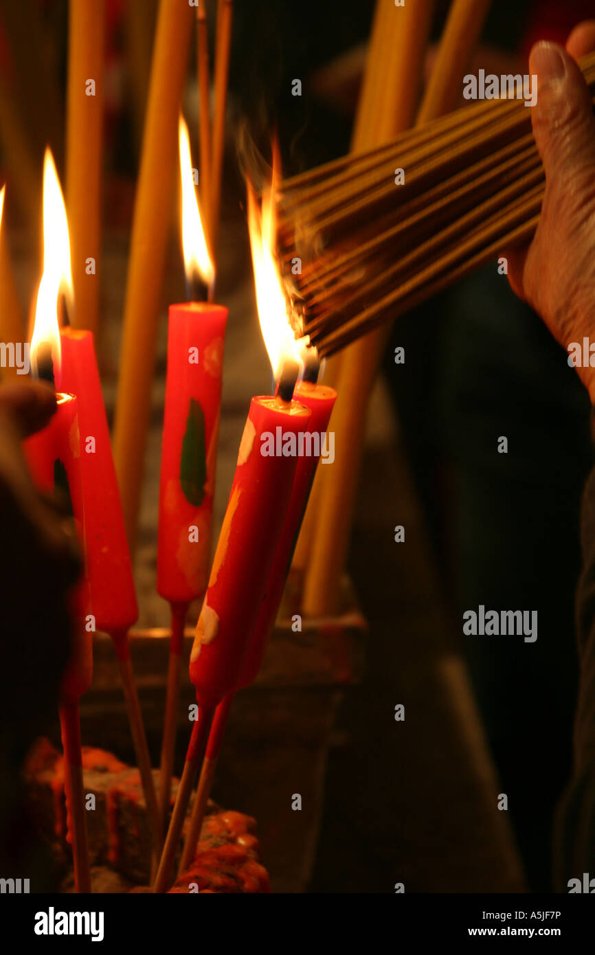 Lighting incense sticks with Chinese red candles in a temple Stock ...