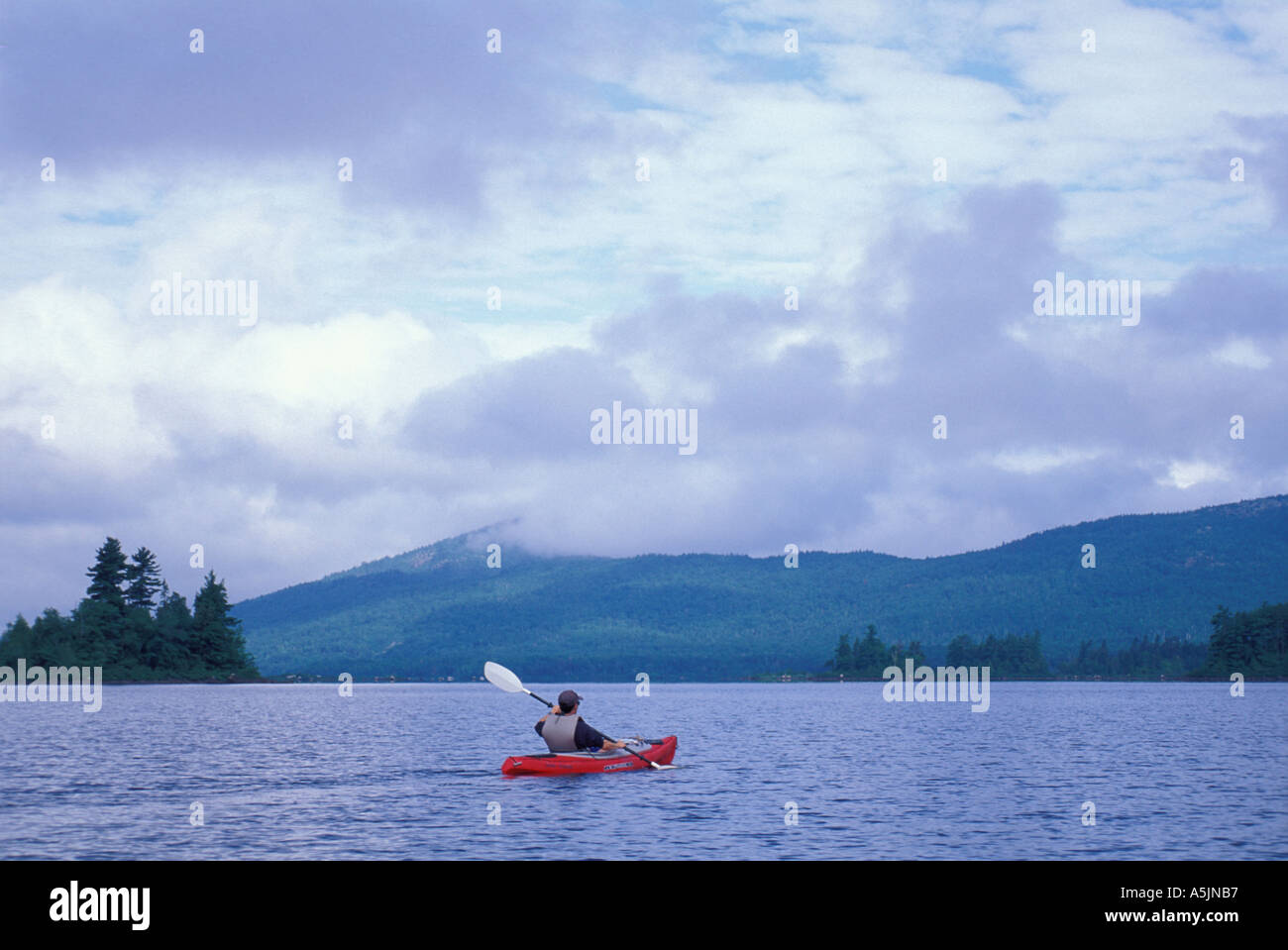 Lone kayaker on Attean Pond with mountains and clouds Stock Photo - Alamy