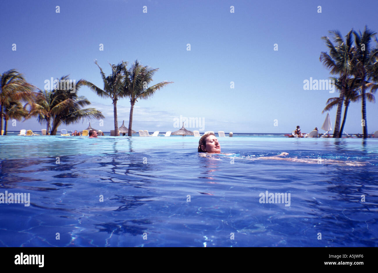 Mauritius hotel swimming pool and woman swimmer Stock Photo - Alamy