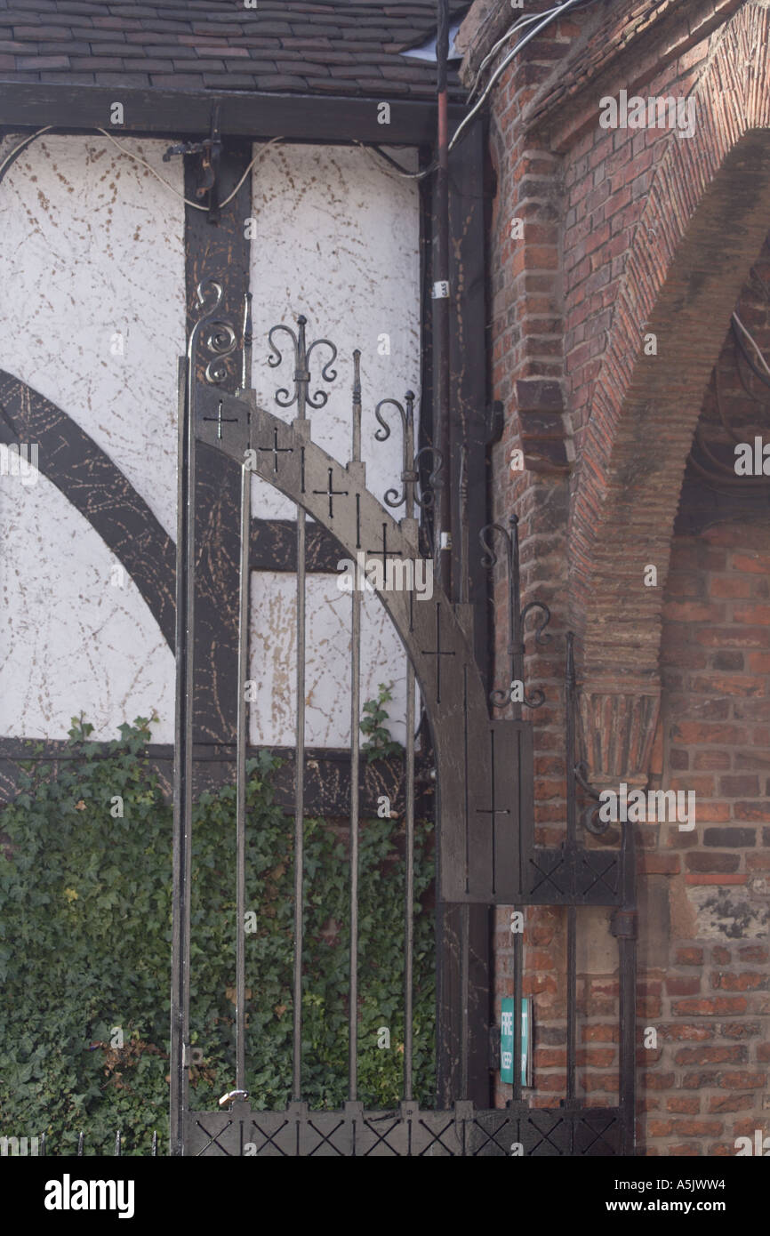 Corner structure including brick archway and iron gate Stock Photo - Alamy