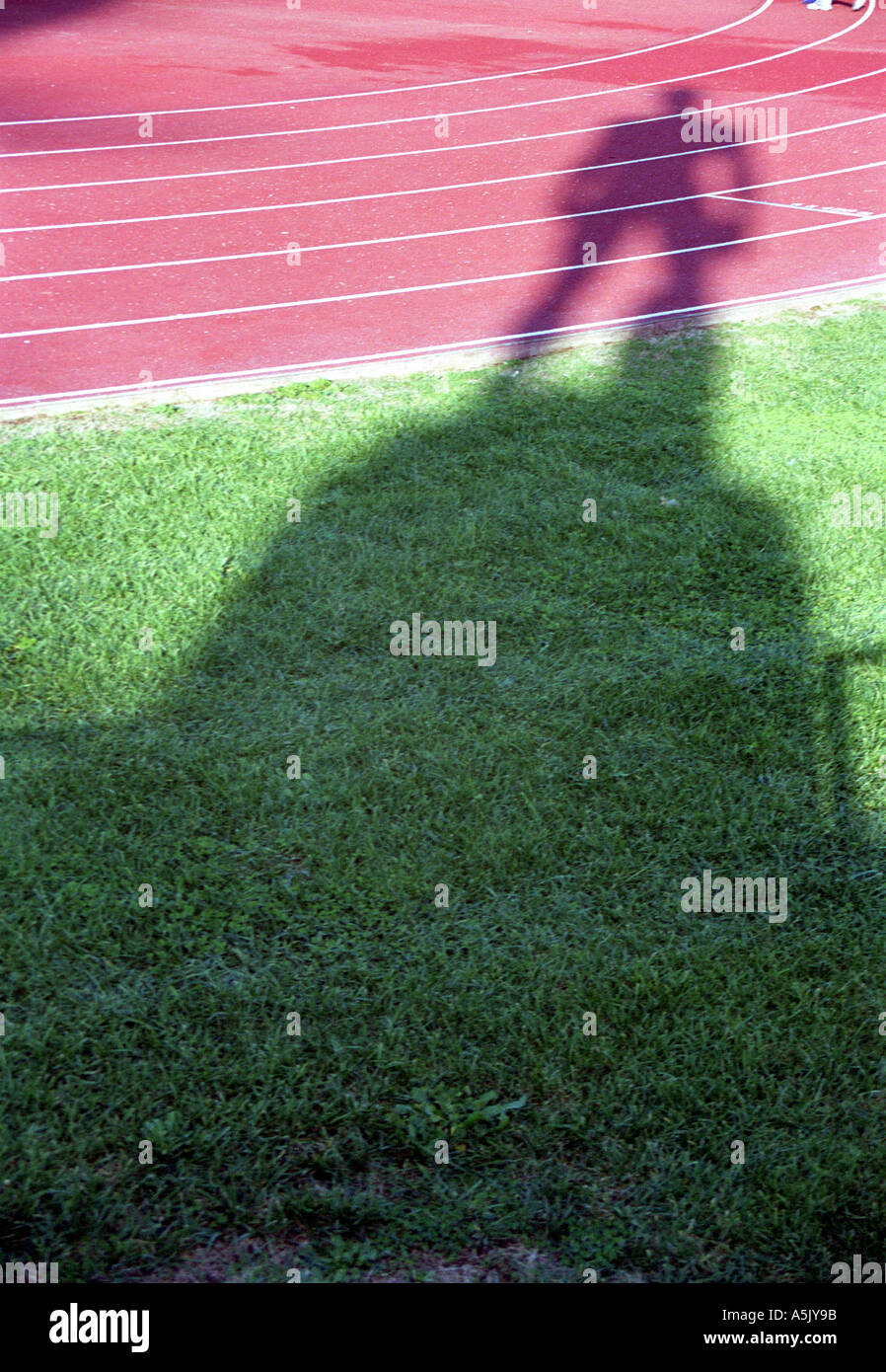 statue man s shadow over athletics track Stock Photo - Alamy