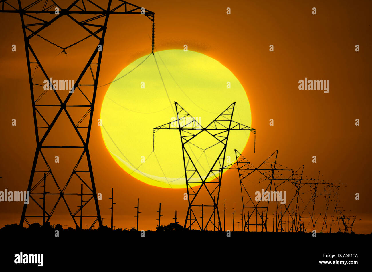 huge sunset behind power lines poles in Florida Stock Photo - Alamy