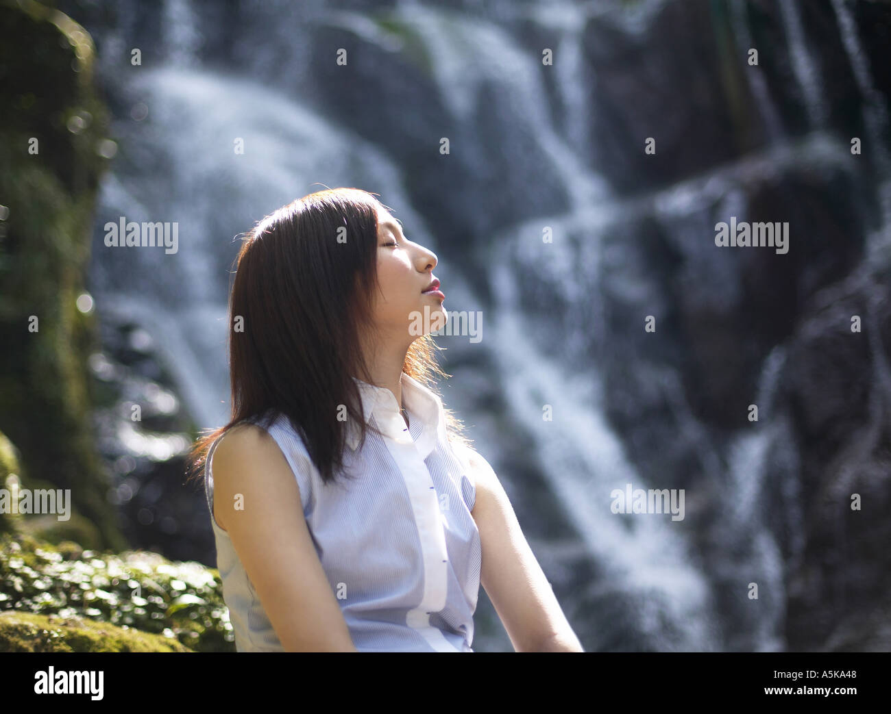 Woman sitting beside waterfall hi-res stock photography and images - Alamy