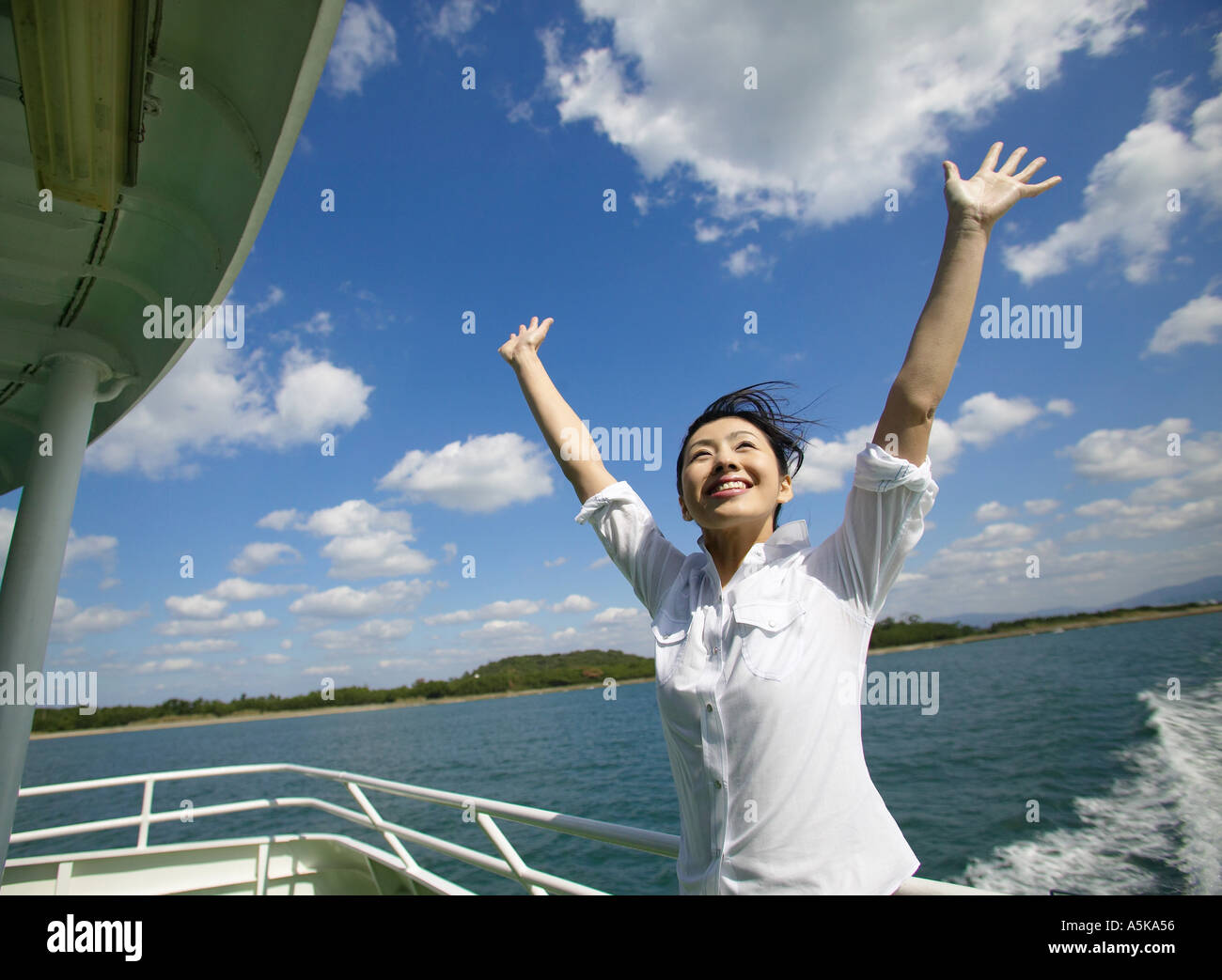 Young woman on a boat with arms outstretched Stock Photo - Alamy