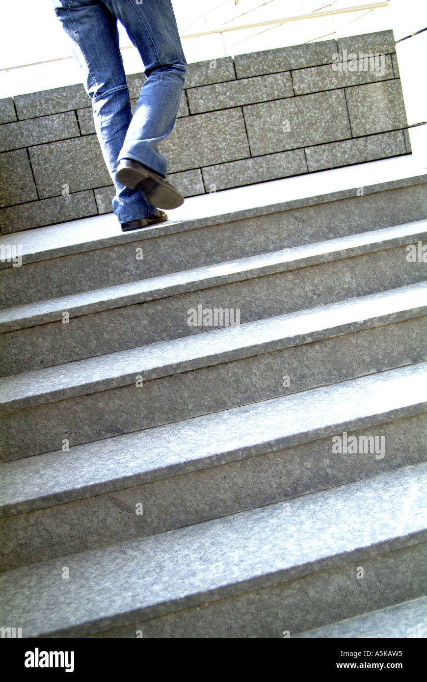 A woman in jeans going up the stairs Stock Photo - Alamy