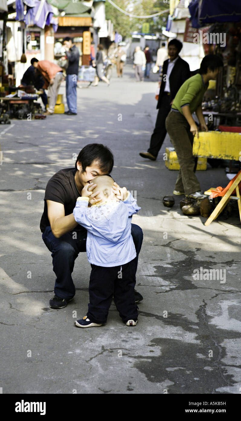 CHINA SHANGHAI Chinese father squats to hug his toddler son in a street ...