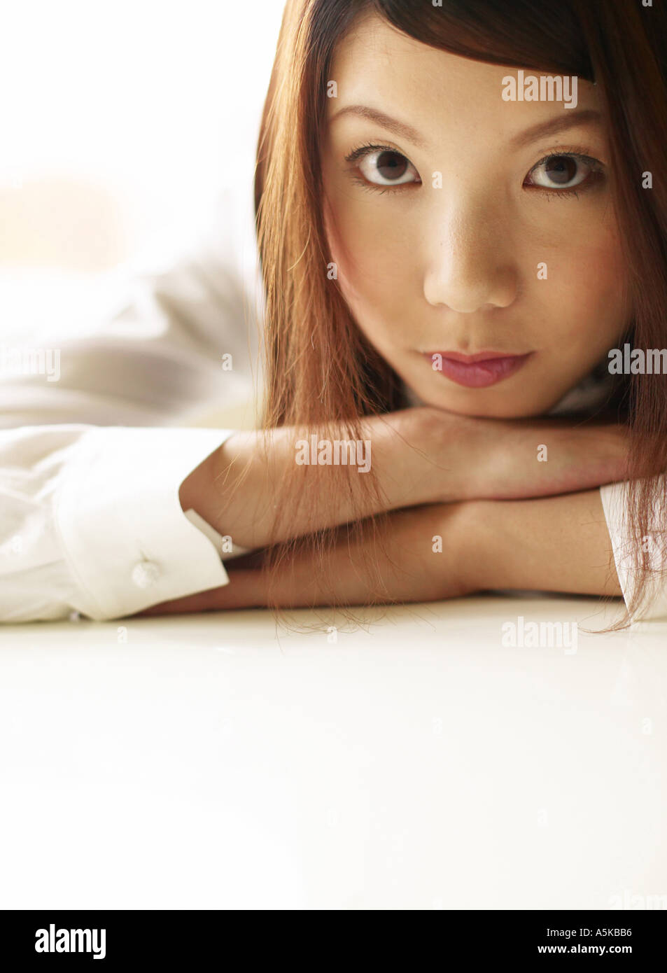 Young women resting her face on her arms Stock Photo - Alamy