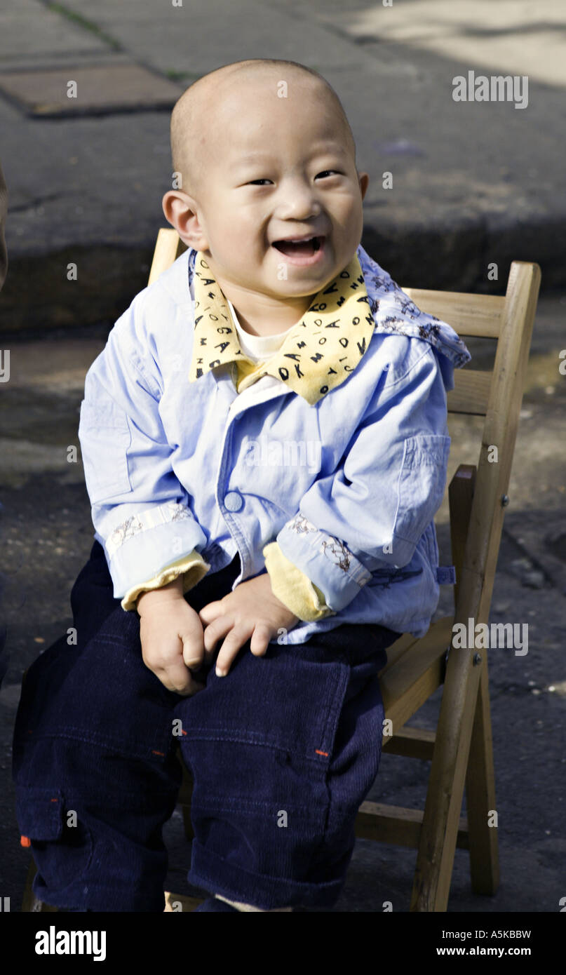 CHINA SHANGHAI Adorable Chinese boy toddler laughing as he sits beside ...