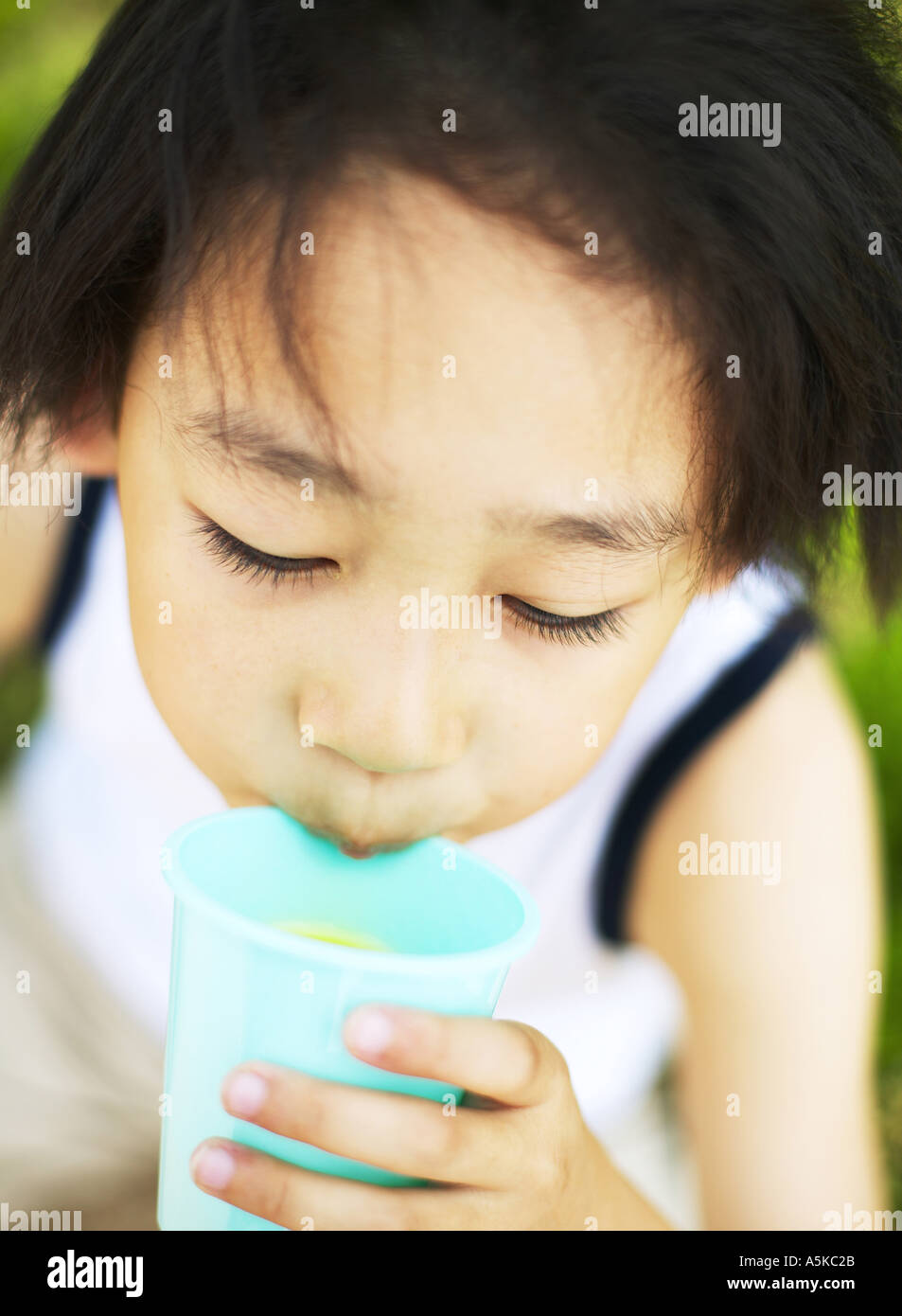 Young boy drinking from plastic cup Stock Photo - Alamy