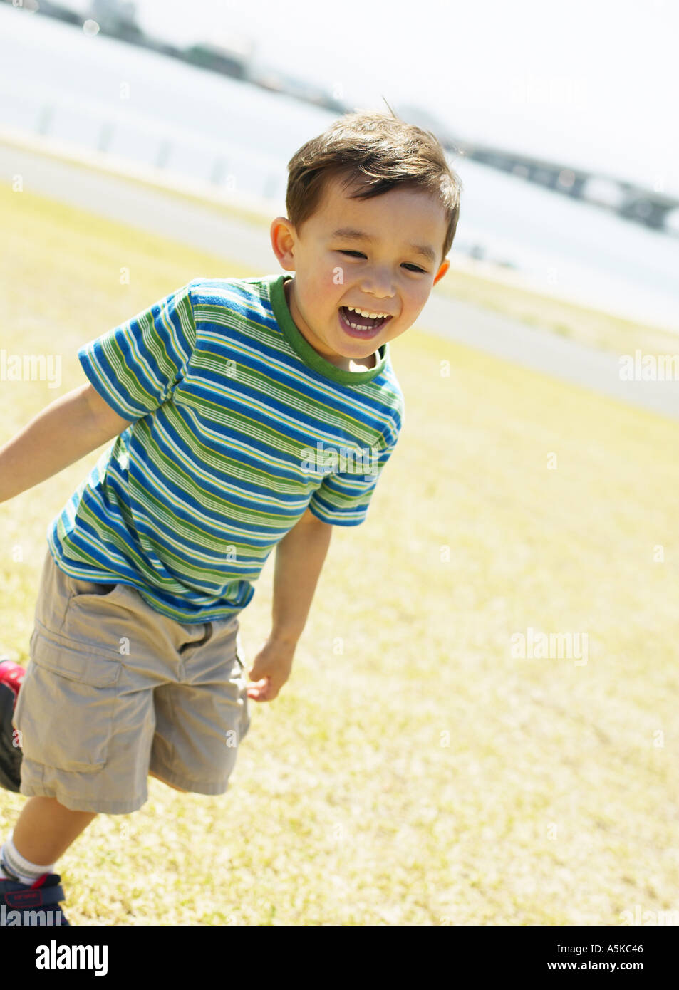 Young boy running and smiling Stock Photo - Alamy