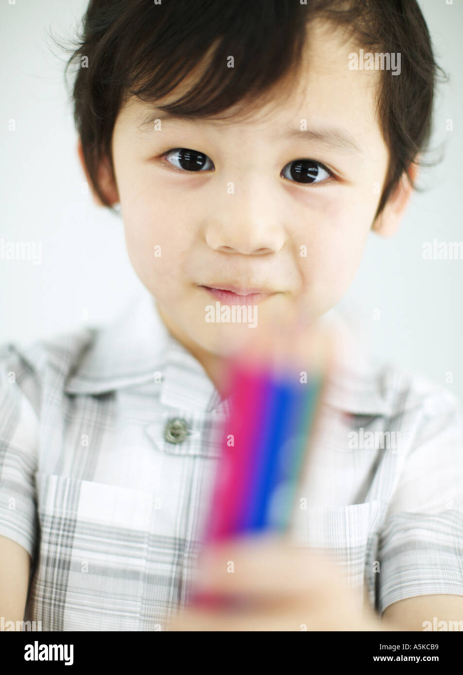 Young boy holding color pencils Stock Photo - Alamy