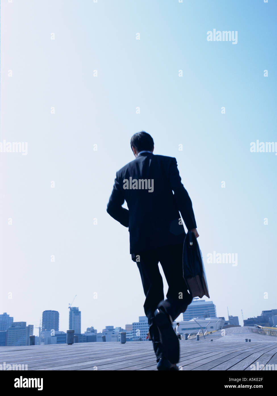 Back profile of a man walking on a bridge Stock Photo - Alamy