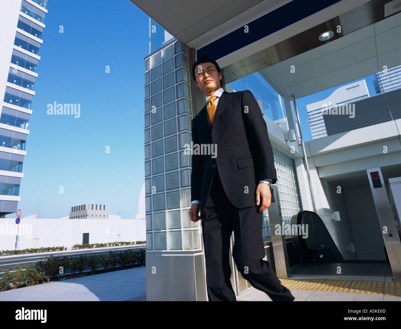 Asian Man walking out of an office Stock Photo - Alamy
