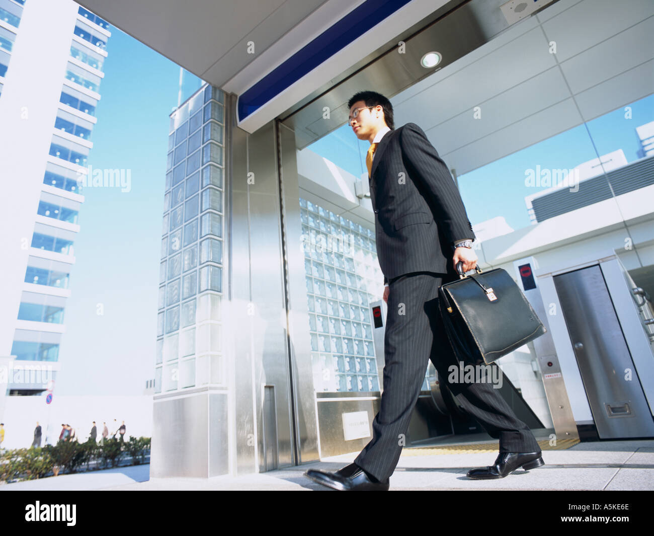 Asian Man walking out of an office Stock Photo - Alamy