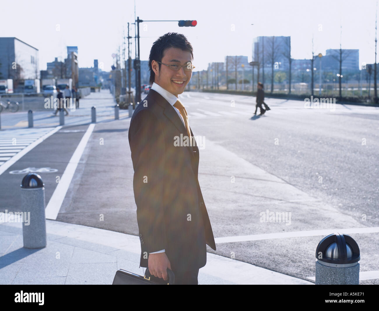 Asian Man waiting at a curb Stock Photo - Alamy