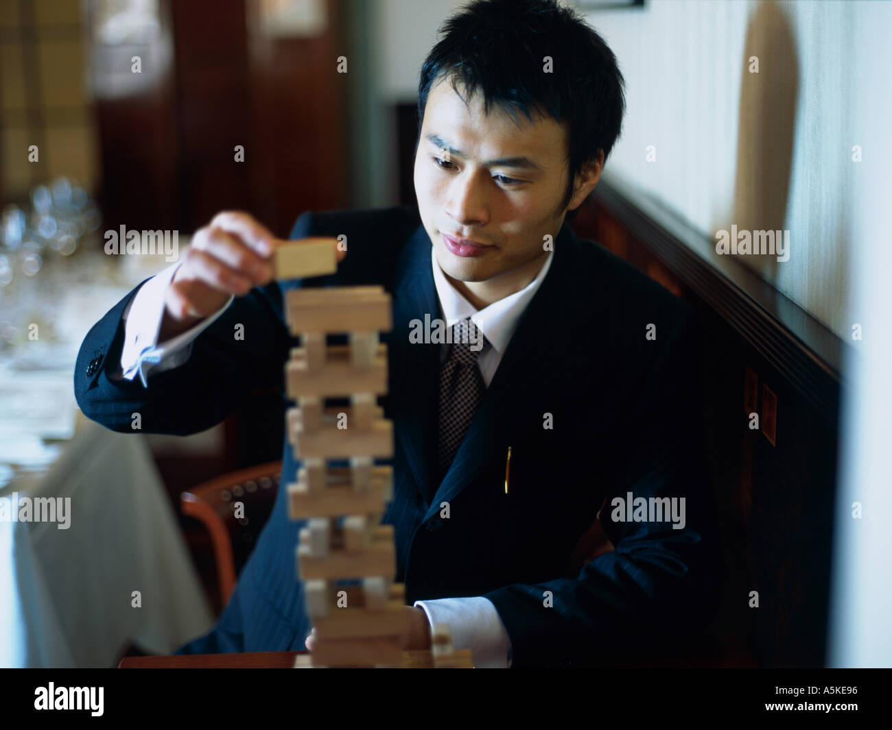 Asian Man making a tower of blocks Stock Photo - Alamy