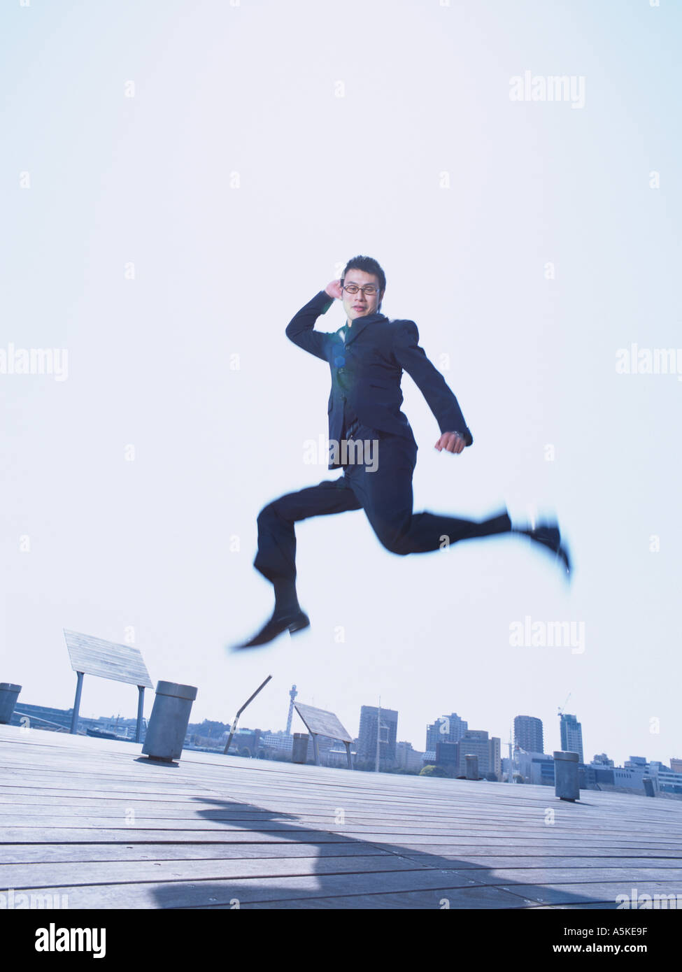 Asian Man jumping on a bridge Stock Photo - Alamy