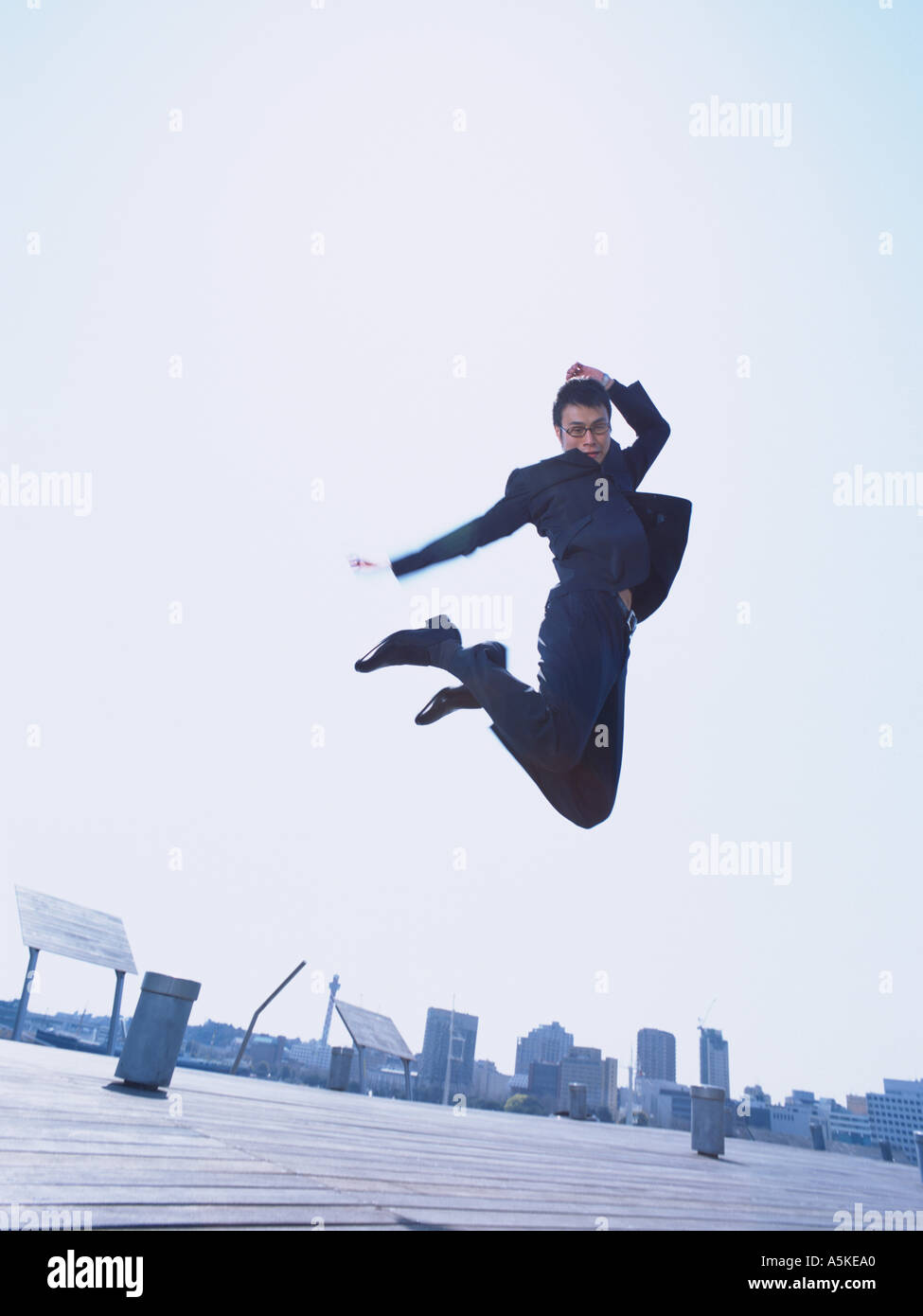 Asian Man jumping on a bridge Stock Photo - Alamy