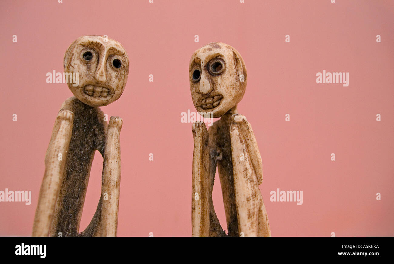 Two carved bone figurines from Indonesia depicted in a crouching ...