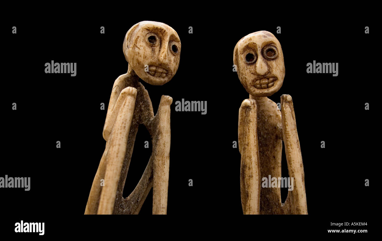 Two carved bone figurines from Indonesia depicted in a crouching ...