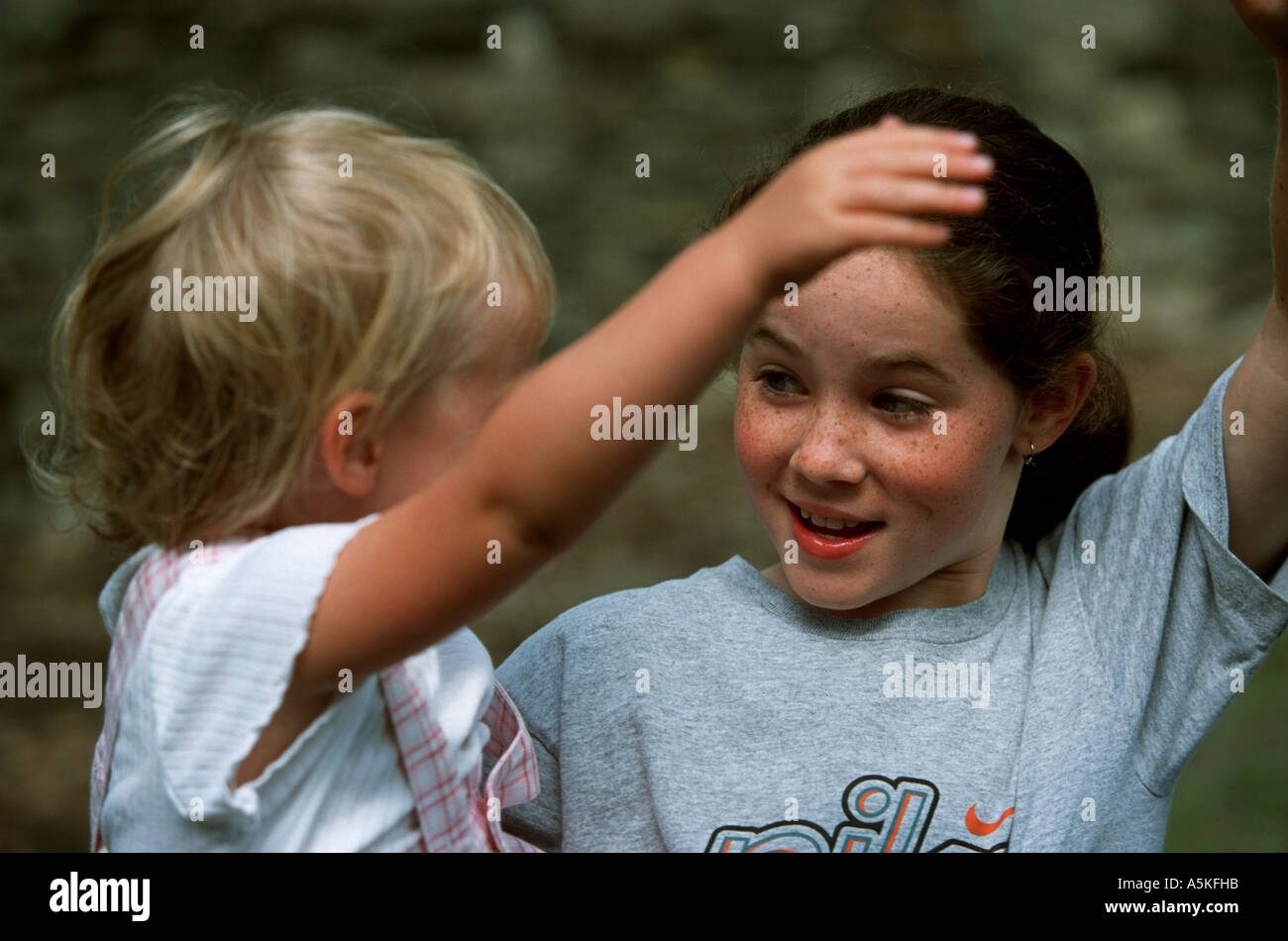 a-10-year-old-girl-is-explaining-something-to-a-toddler-girl-as-they