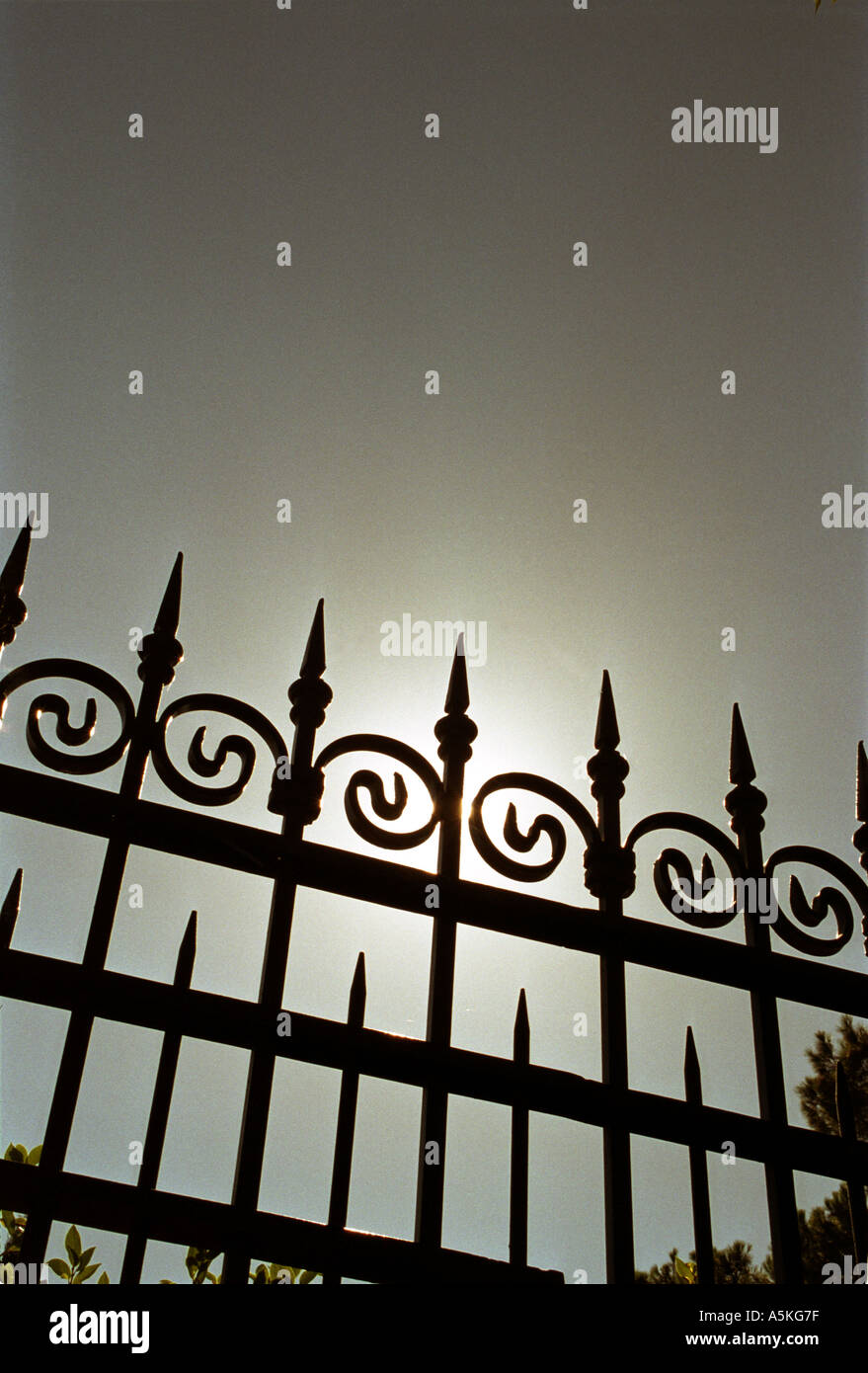 wrought iron gate with sun breaking through Stock Photo - Alamy