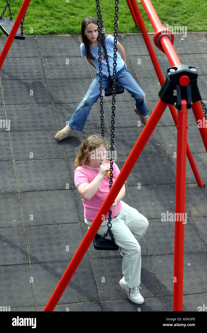 2 young girls children playing on swings in park taken from above Stock Photo - Alamy