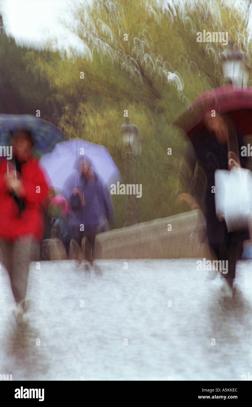 people crossing bridge with umbrellas Stock Photo - Alamy